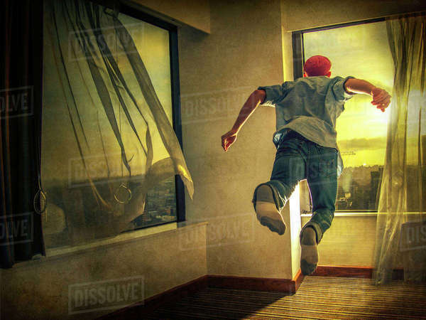 Caucasian man flying through window - Royalty-free Stock Photo | Dissolve