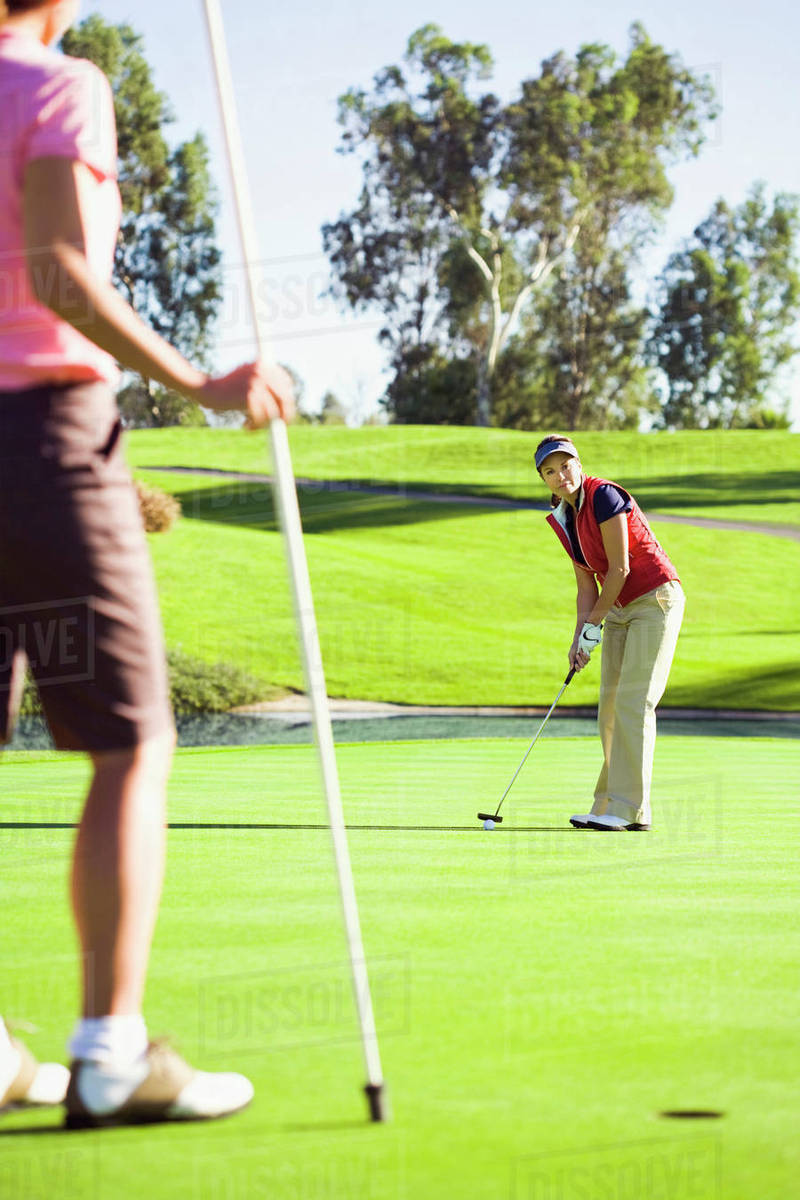Women putting on green at golf course - Royalty-free Stock Photo | Dissolve
