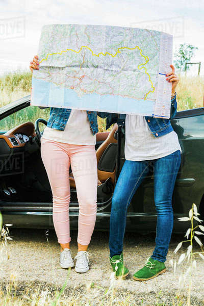 Women reading map on road trip - Royalty-free Stock Photo | Dissolve