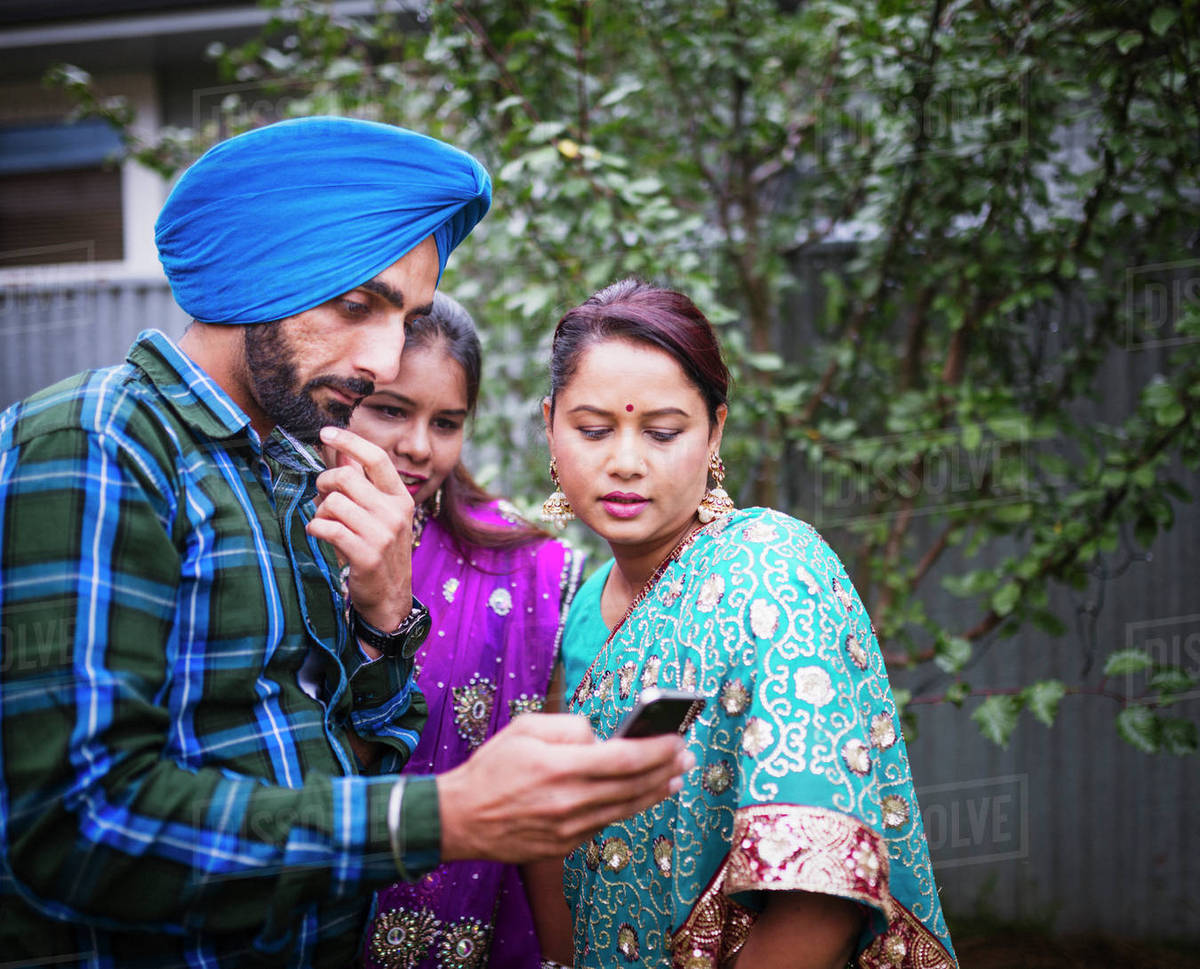 Family in traditional Indian clothing using cell phone - Stock Photo ...