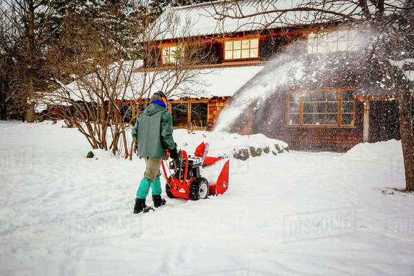 Caucasian man using snow blower in snowy driveway - Royalty-free Stock ...