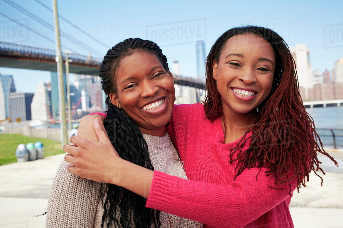 Black women hugging at waterfront - Royalty-free Stock Photo | Dissolve