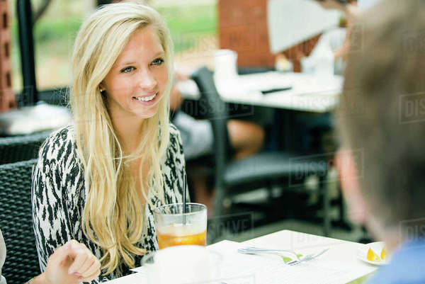 Smiling Caucasian woman sitting at restaurant table - Royalty-free ...