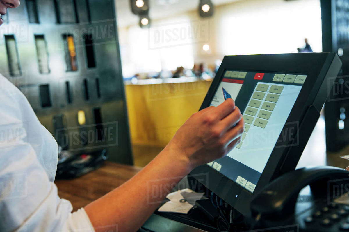 Caucasian cashier using touch screen to process credit card payment ...