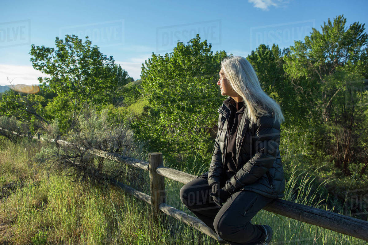 Older Caucasian woman sitting on wooden fence - Royalty-free Stock ...