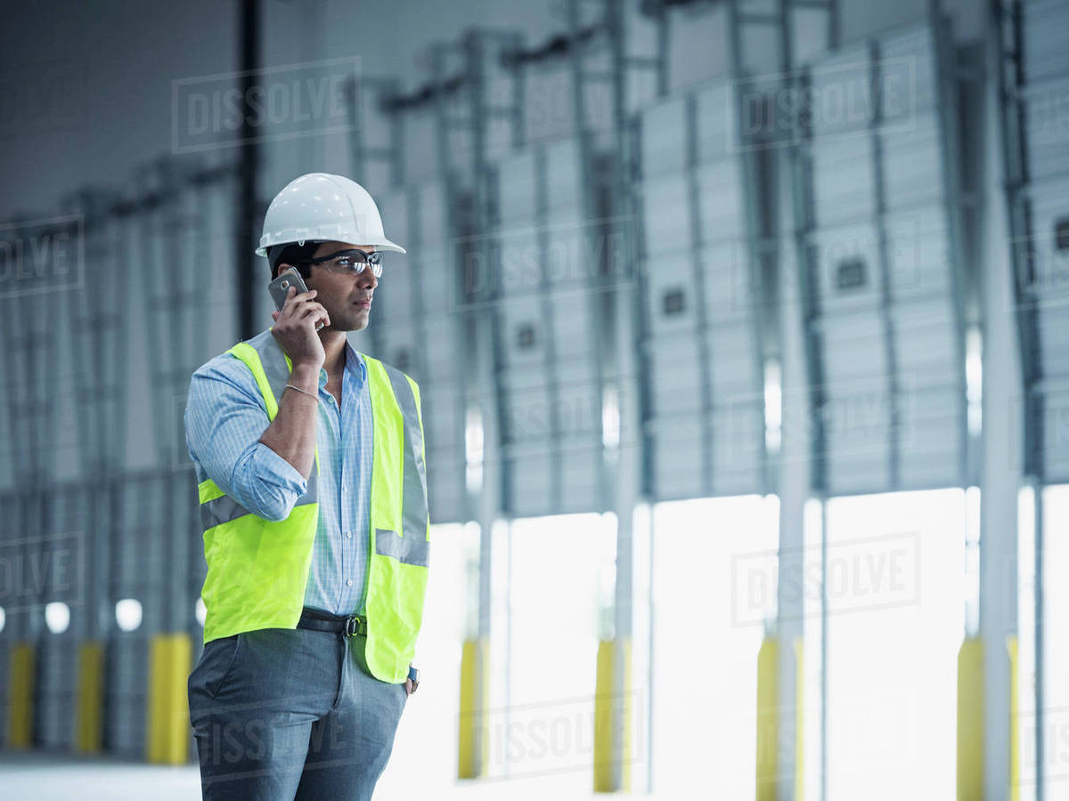 Indian worker talking on cell phone at loading dock - Royalty-free ...