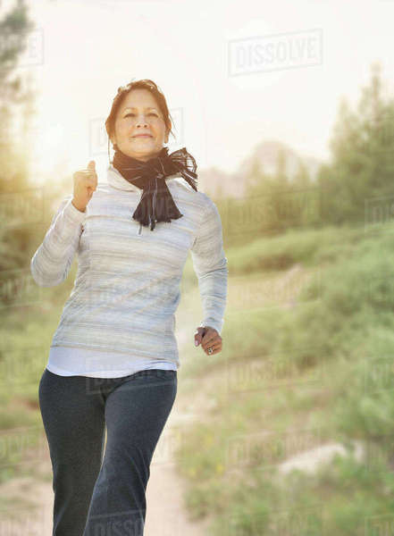 Hispanic woman running on trail - Royalty-free Stock Photo | Dissolve
