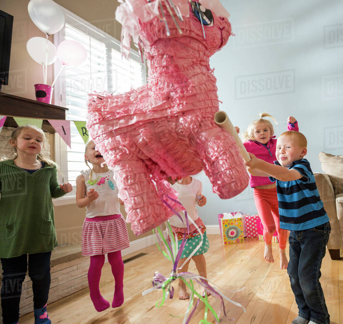 Caucasian boy hitting pinata at party - Stock Photo - Dissolve