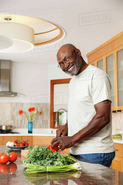 Black man chopping vegetables in kitchen - Royalty-free Stock Photo ...