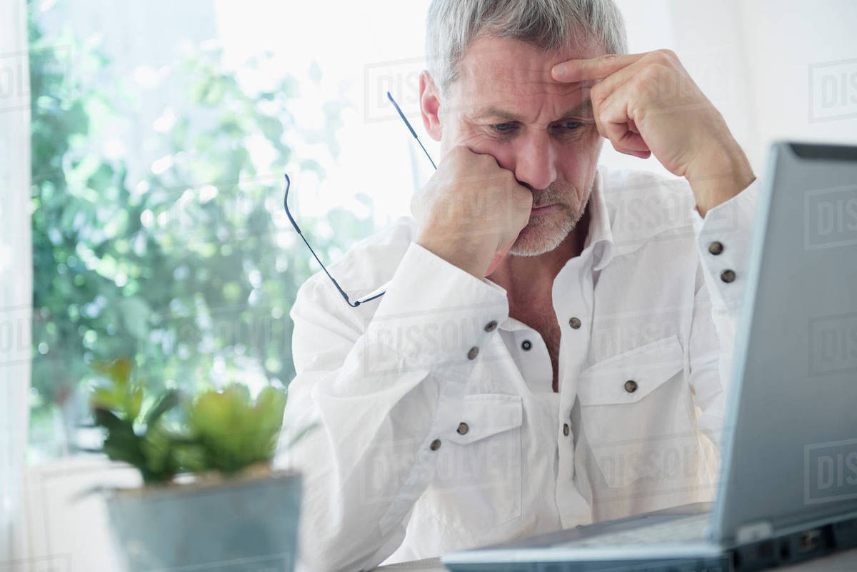 Frustrated older Caucasian man using laptop - Royalty-free Stock Photo ...