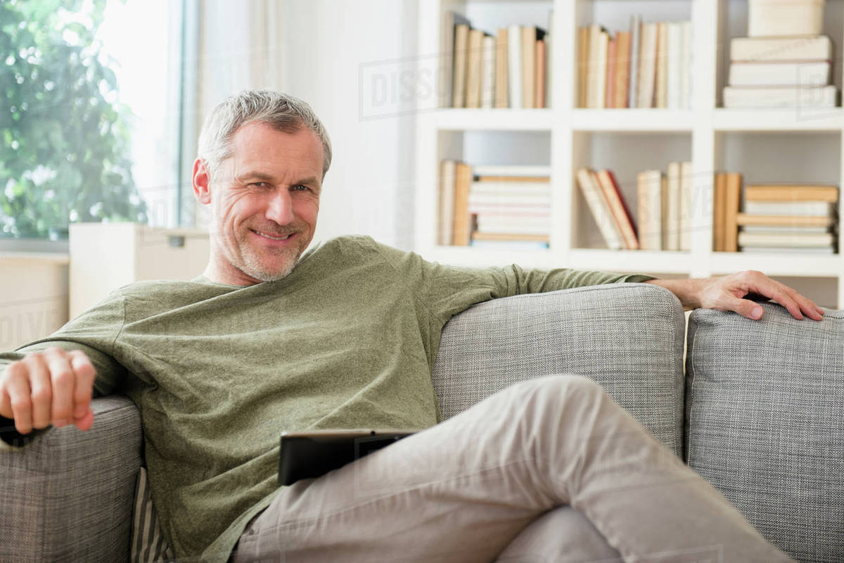 Older Caucasian man sitting on sofa with digital tablet - Stock Photo ...