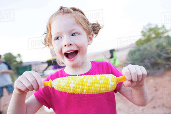 Caucasian girl eating corn on the cob - Royalty-free Stock Photo | Dissolve
