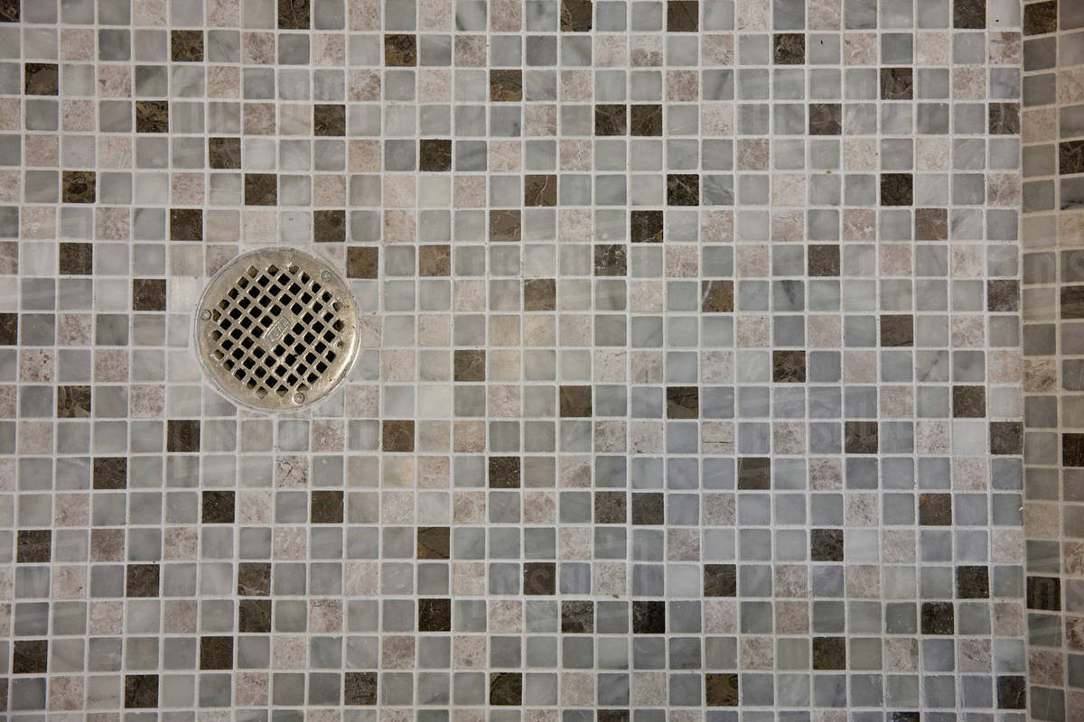 Close-up of drain in mosaic tile floor in the bathroom at home ...