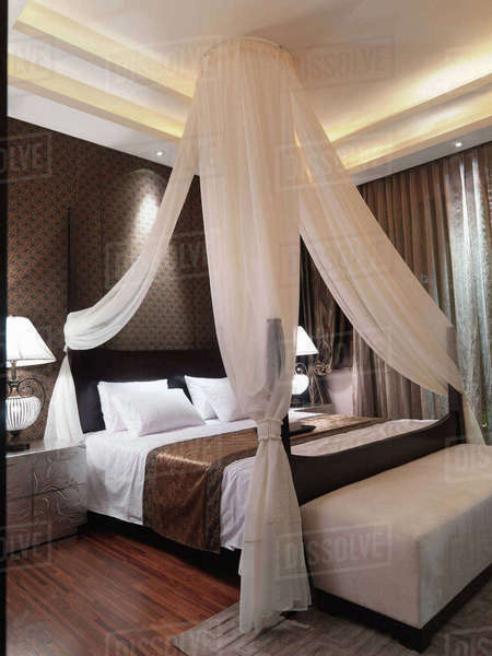 Mosquito net above bed - Stock Photo - Dissolve