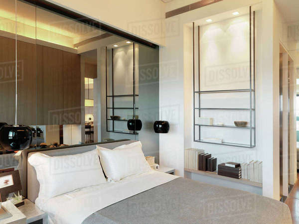 Mirror above headboard in bedroom - Stock Photo - Dissolve