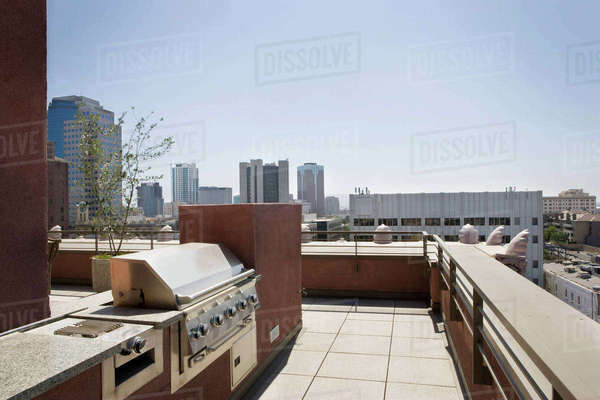 BBQ area on patio with city view in background. - Stock Photo - Dissolve