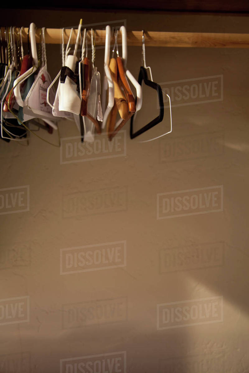 Empty hangers hanging on wooden rod - Stock Photo - Dissolve