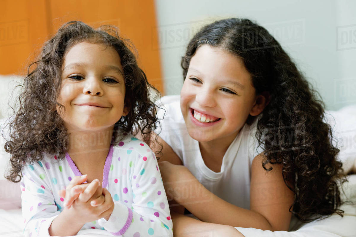 Hispanic sisters laughing - Stock Photo - Dissolve