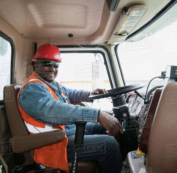 African construction worker driving truck - Stock Photo - Dissolve