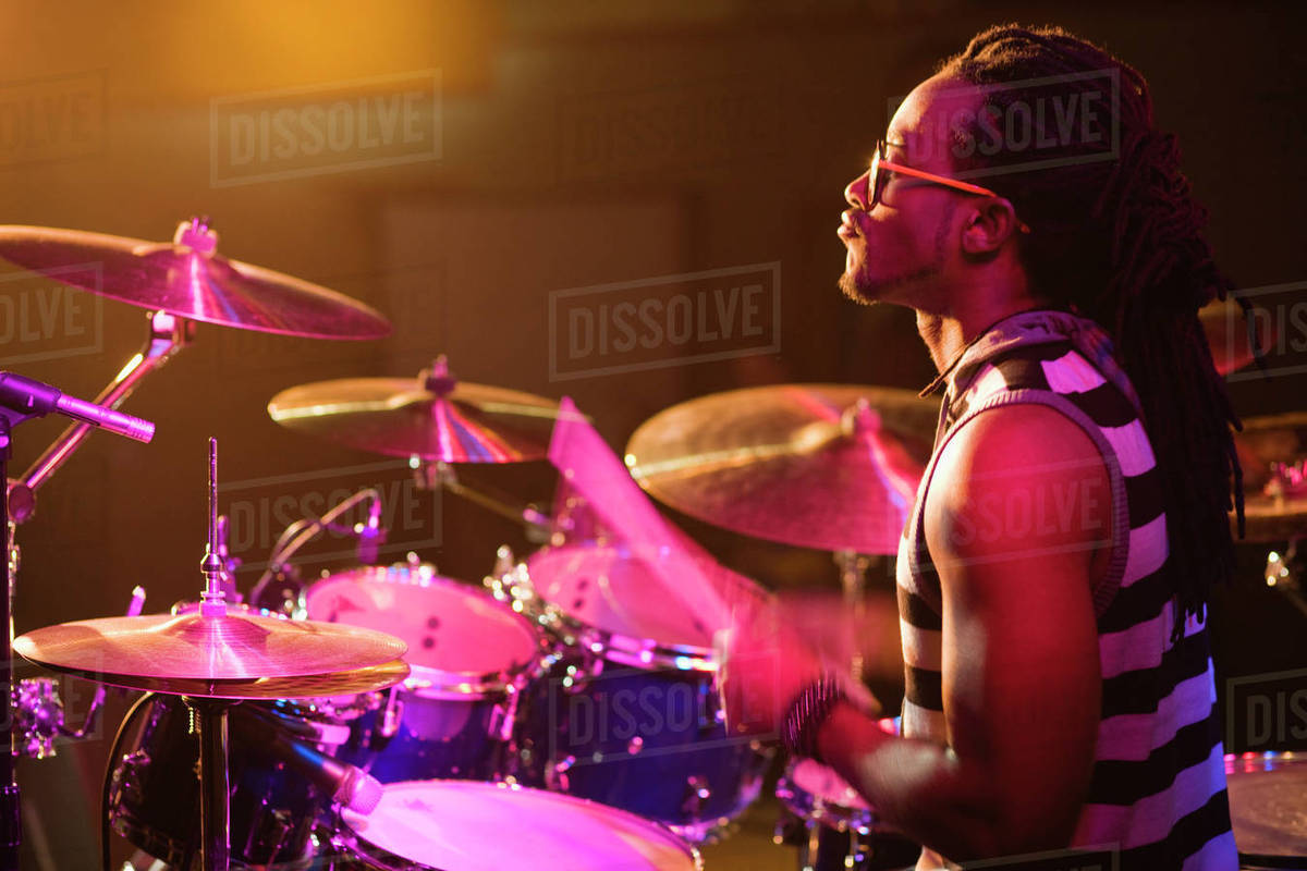 African man playing drums onstage - Royalty-free Stock Photo | Dissolve