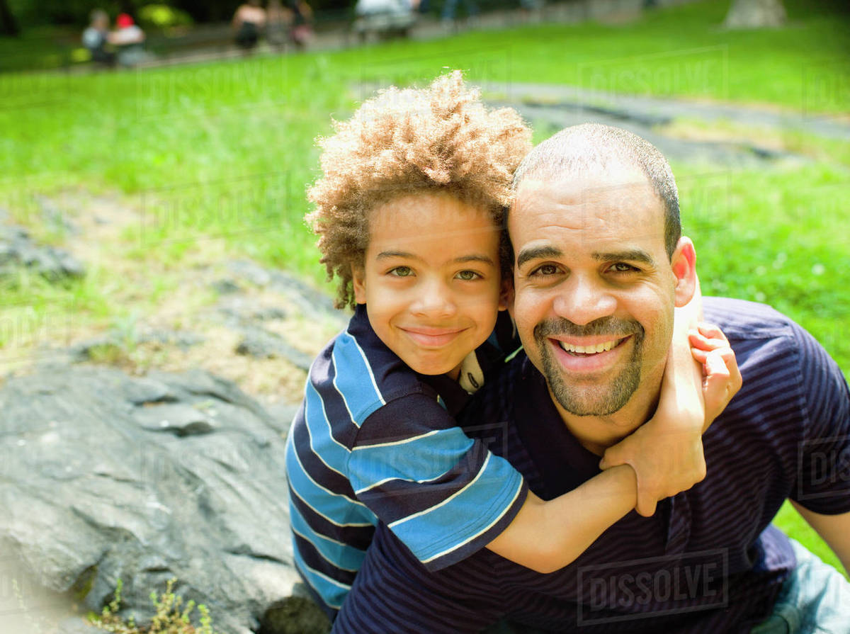 Boy hugging father outdoors - Royalty-free Stock Photo | Dissolve