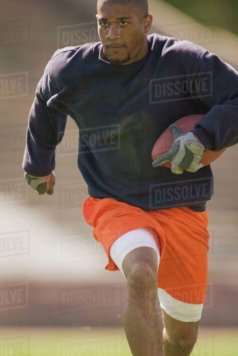 Man running with football - Royalty-free Stock Photo | Dissolve