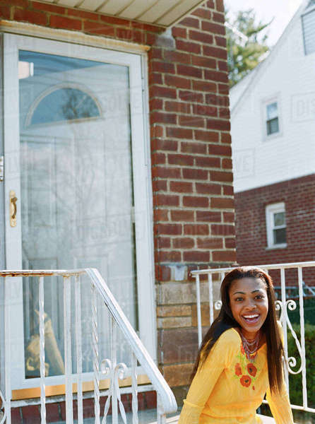 Woman sitting on front stoop - Stock Photo - Dissolve