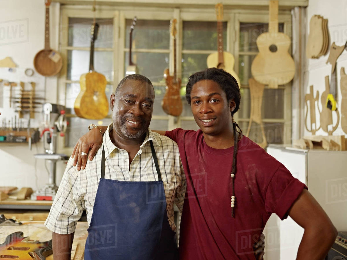 Black craftsman in guitar workshop with son - Royalty-free Stock Photo ...