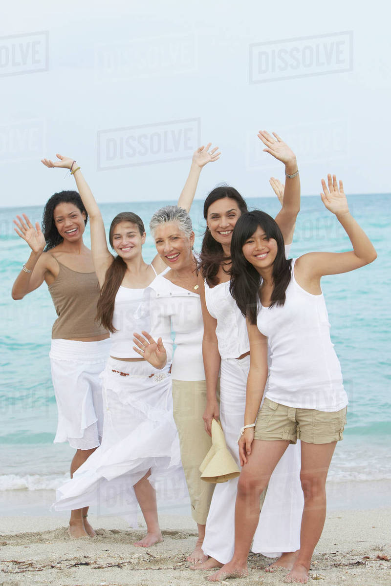 Diverse women standing on beach together waving - Royalty-free Stock ...