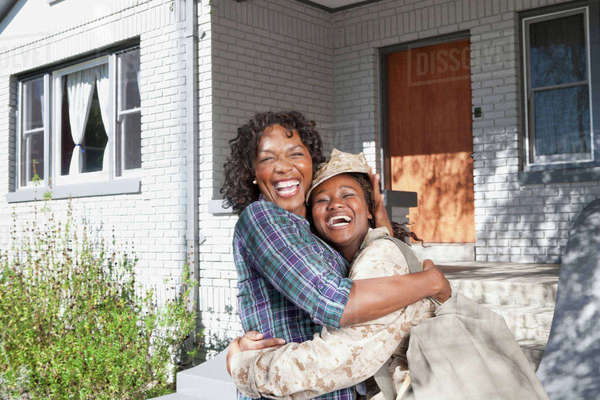 Black mother hugging soldier daughter - Stock Photo - Dissolve