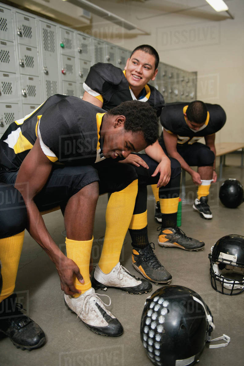Football players dressing in locker room - Stock Photo - Dissolve