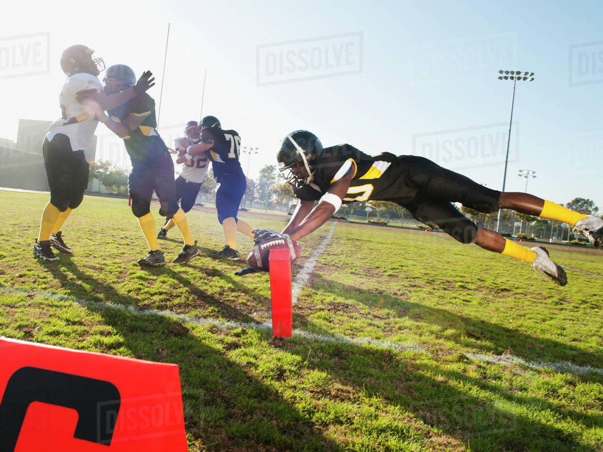 Football player scoring goal on football field - Stock Photo - Dissolve