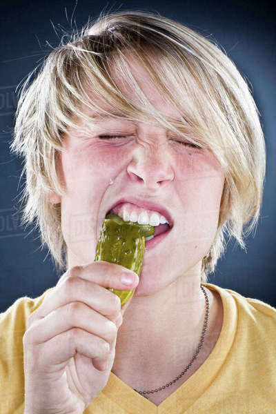 Caucasian boy eating pickle - Royalty-free Stock Photo | Dissolve