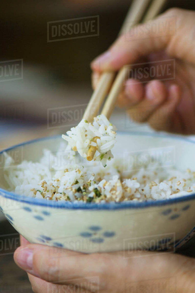 Person eating bowl of rice with chopsticks - Royalty-free Stock Photo ...