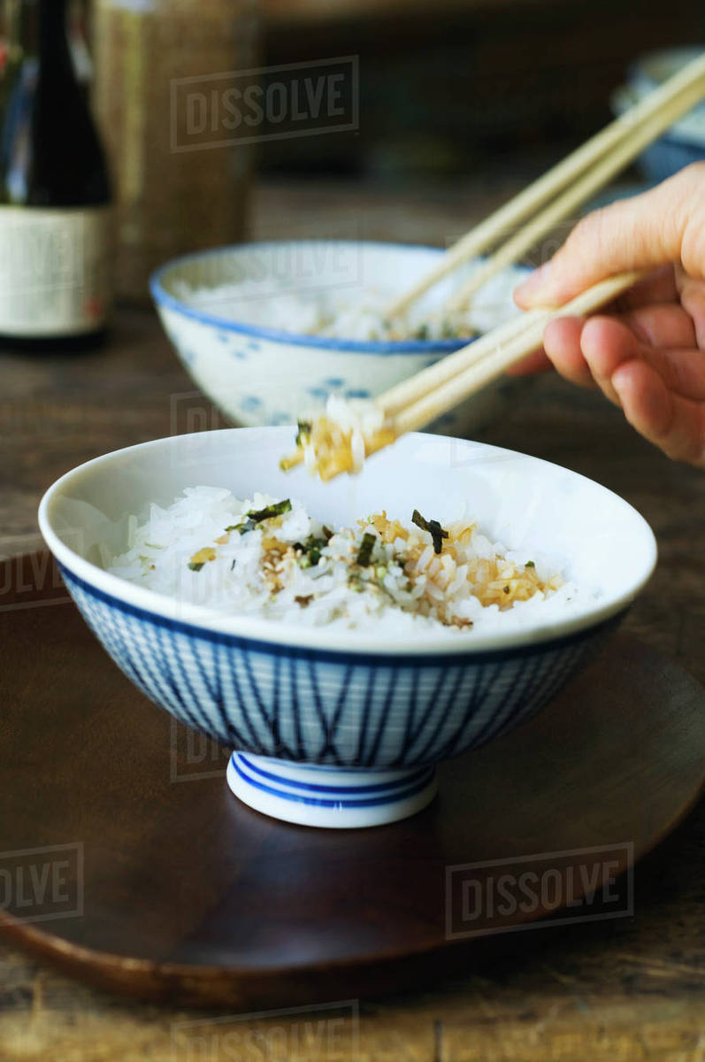 Person eating rice with chopsticks - Royalty-free Stock Photo | Dissolve