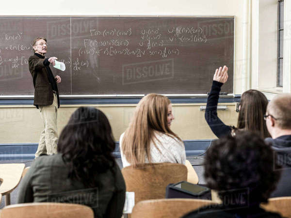 Teacher talking to students in classroom - Royalty-free Stock Photo ...