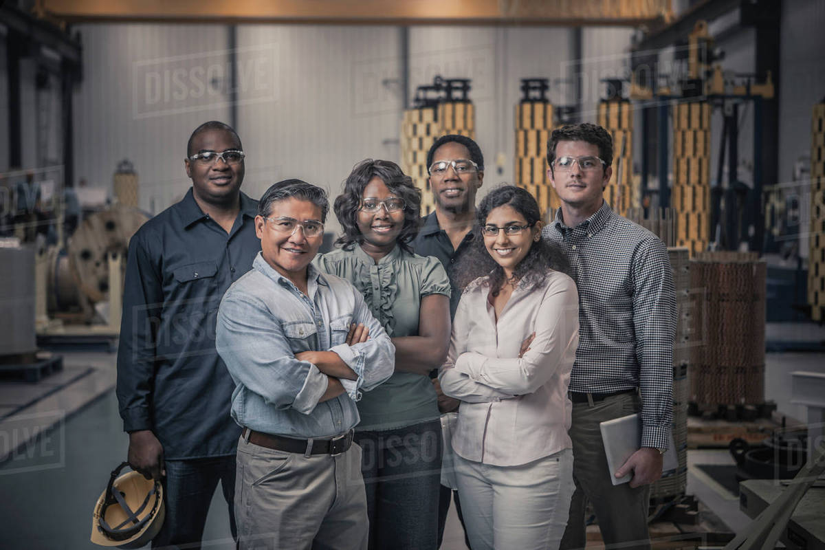 Workers standing together in factory - Royalty-free Stock Photo | Dissolve