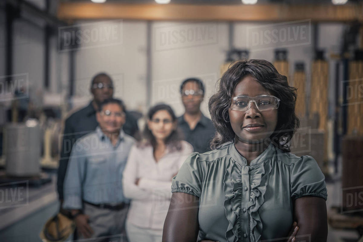 Workers standing together in factory - Royalty-free Stock Photo | Dissolve