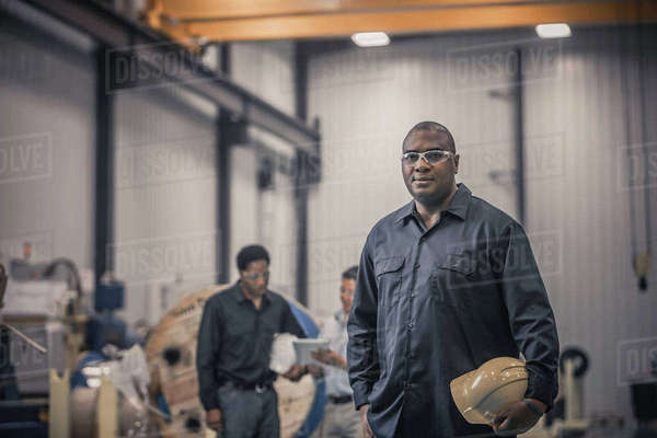 African American worker standing in factory - Stock Photo - Dissolve