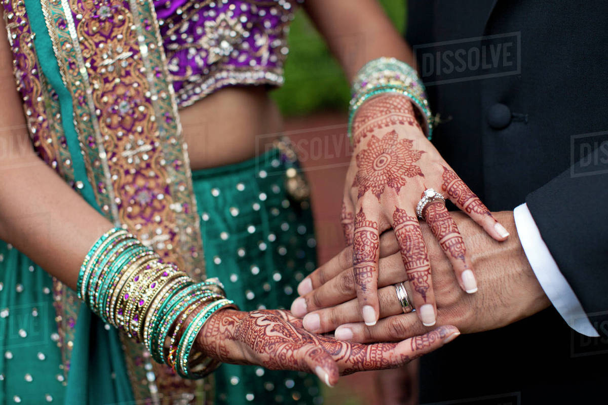 Indian wedding couple with ornate hand decorations - Stock Photo - Dissolve