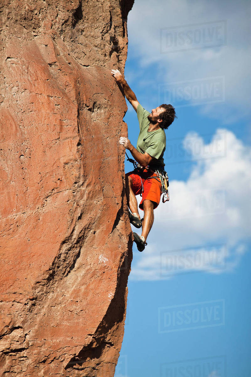 Caucasian man climbing rocks - Royalty-free Stock Photo | Dissolve