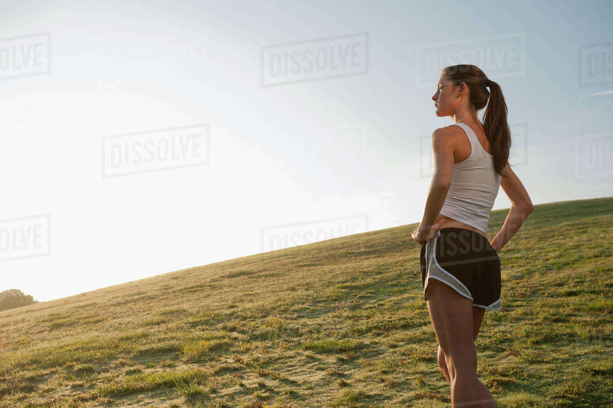 Caucasian runner standing in field - Royalty-free Stock Photo | Dissolve