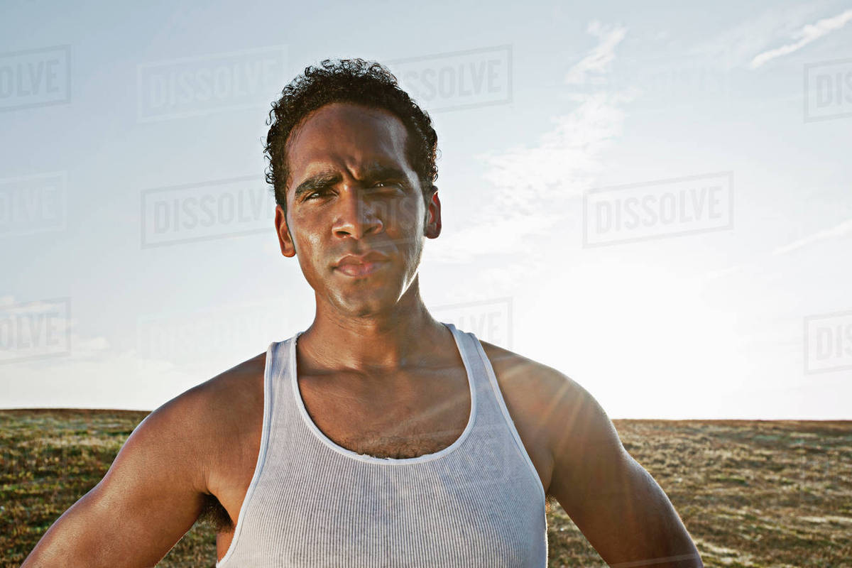Serious Mixed race man standing outdoors - Stock Photo - Dissolve