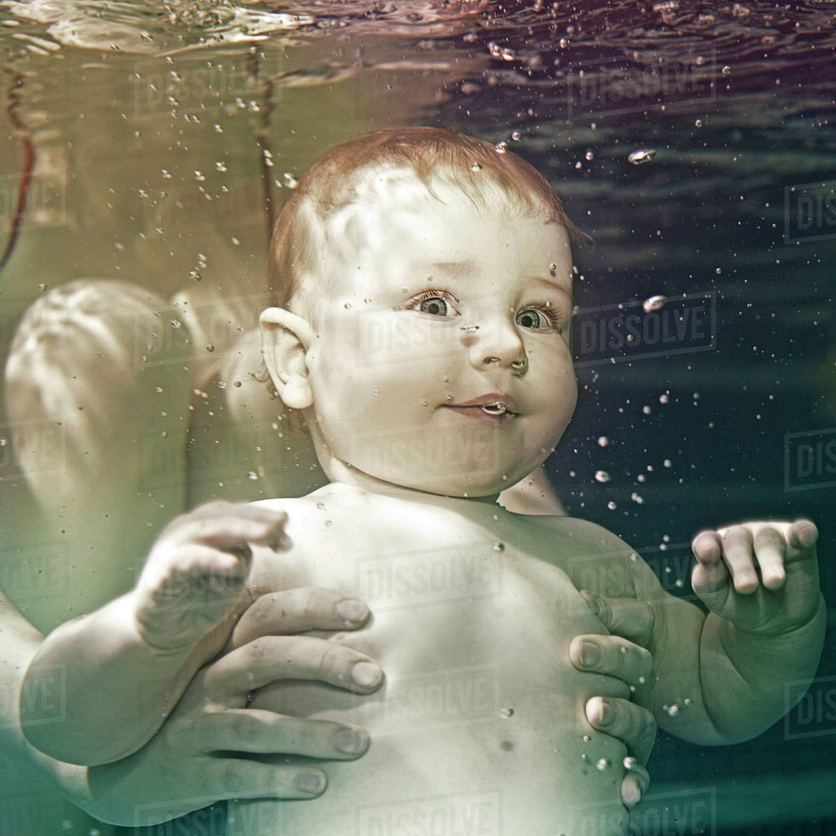 Caucasian baby being held underwater - Royalty-free Stock Photo | Dissolve