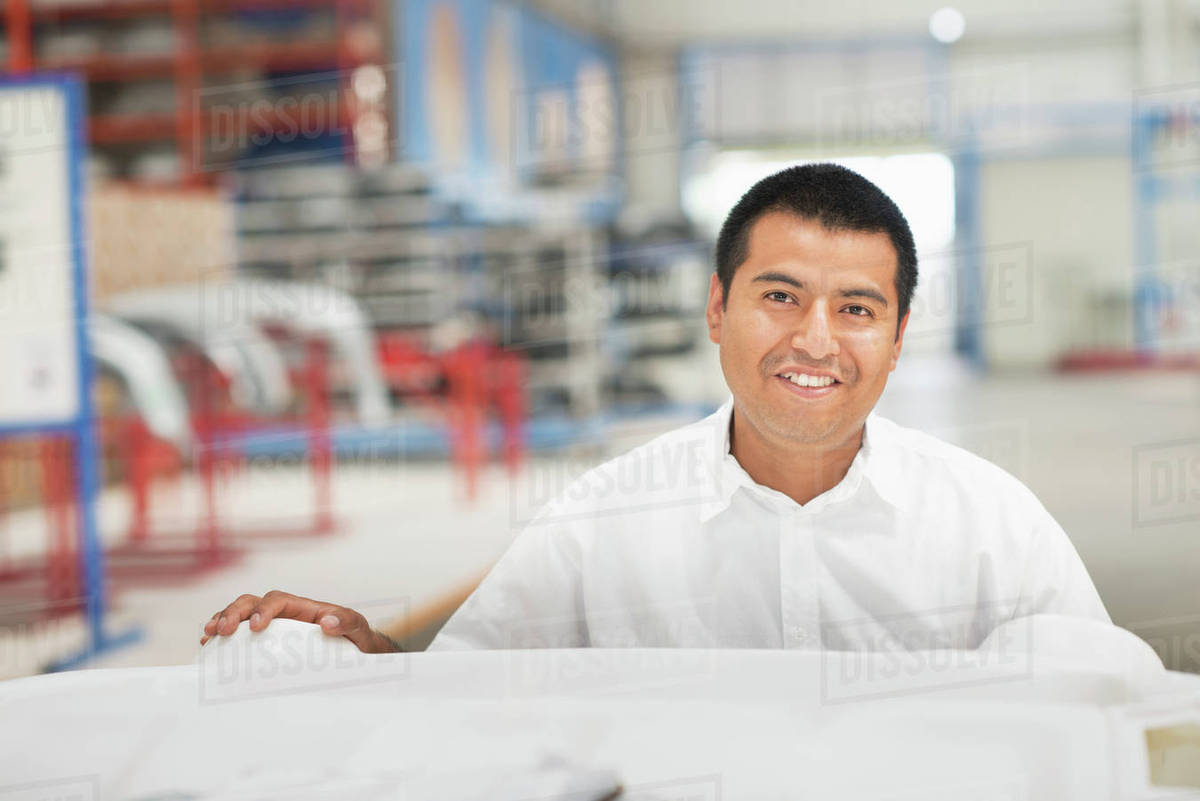 Worker smiling in manufacturing plant - Royalty-free Stock Photo | Dissolve