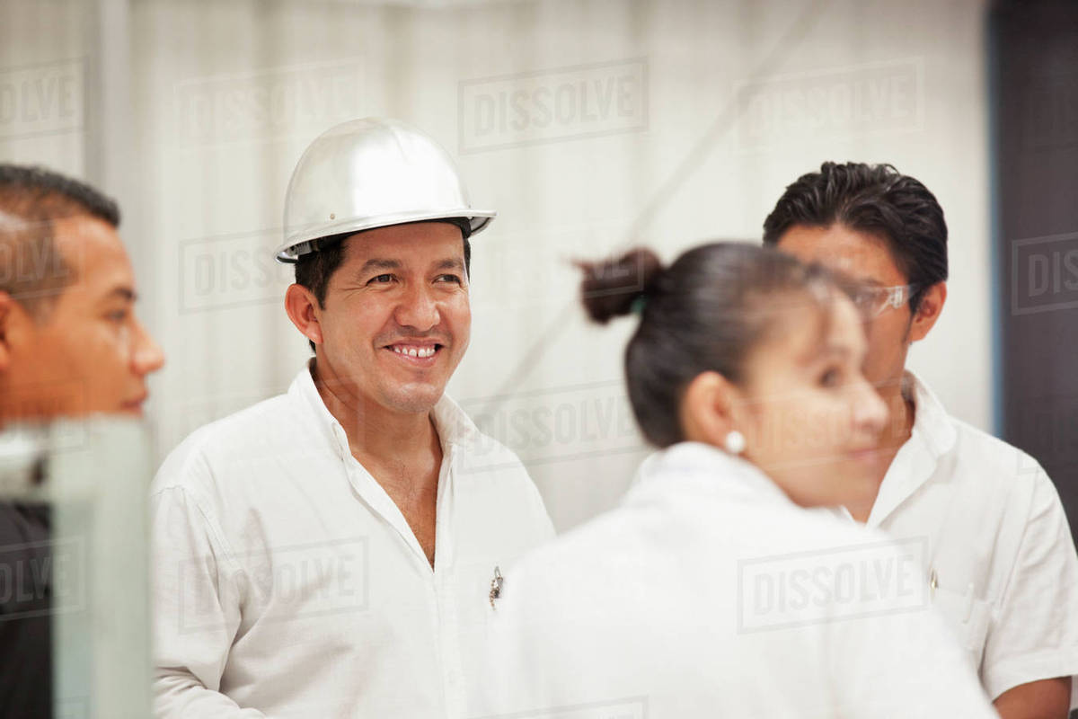 Worker smiling in manufacturing plant - Royalty-free Stock Photo | Dissolve