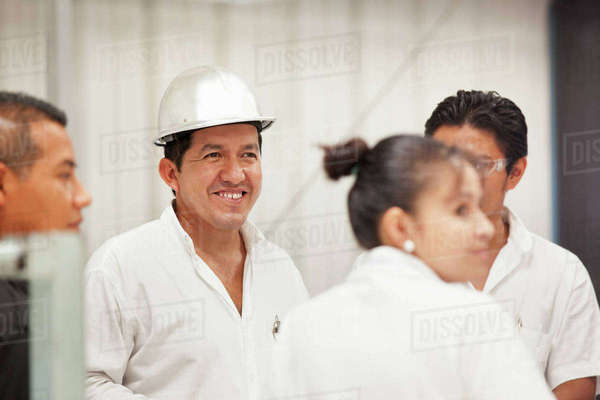 Worker smiling in manufacturing plant - Royalty-free Stock Photo | Dissolve