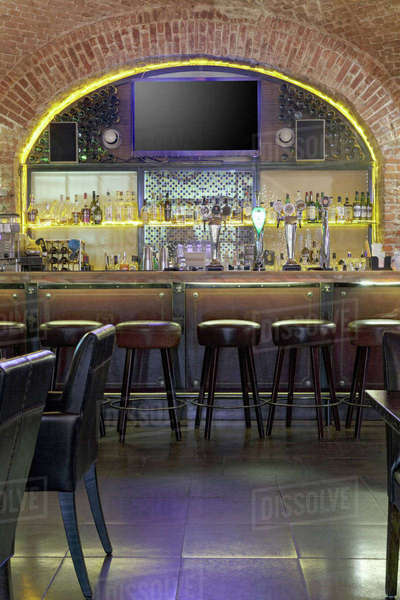 Bar with big TV screen on wall - Stock Photo - Dissolve