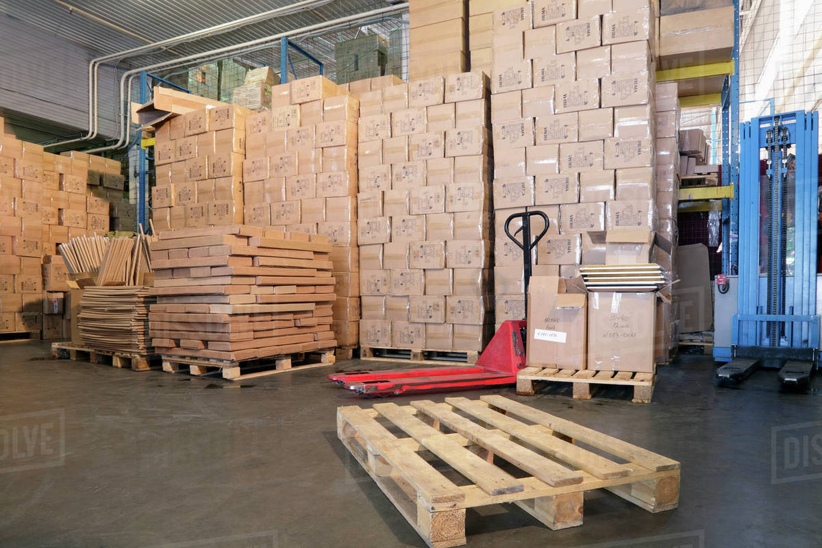 Pallets and cardboard boxes in warehouse - Stock Photo - Dissolve