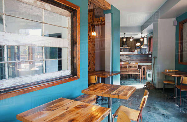 A restaurant with turquoise blue walls and wooden furniture - Royalty ...